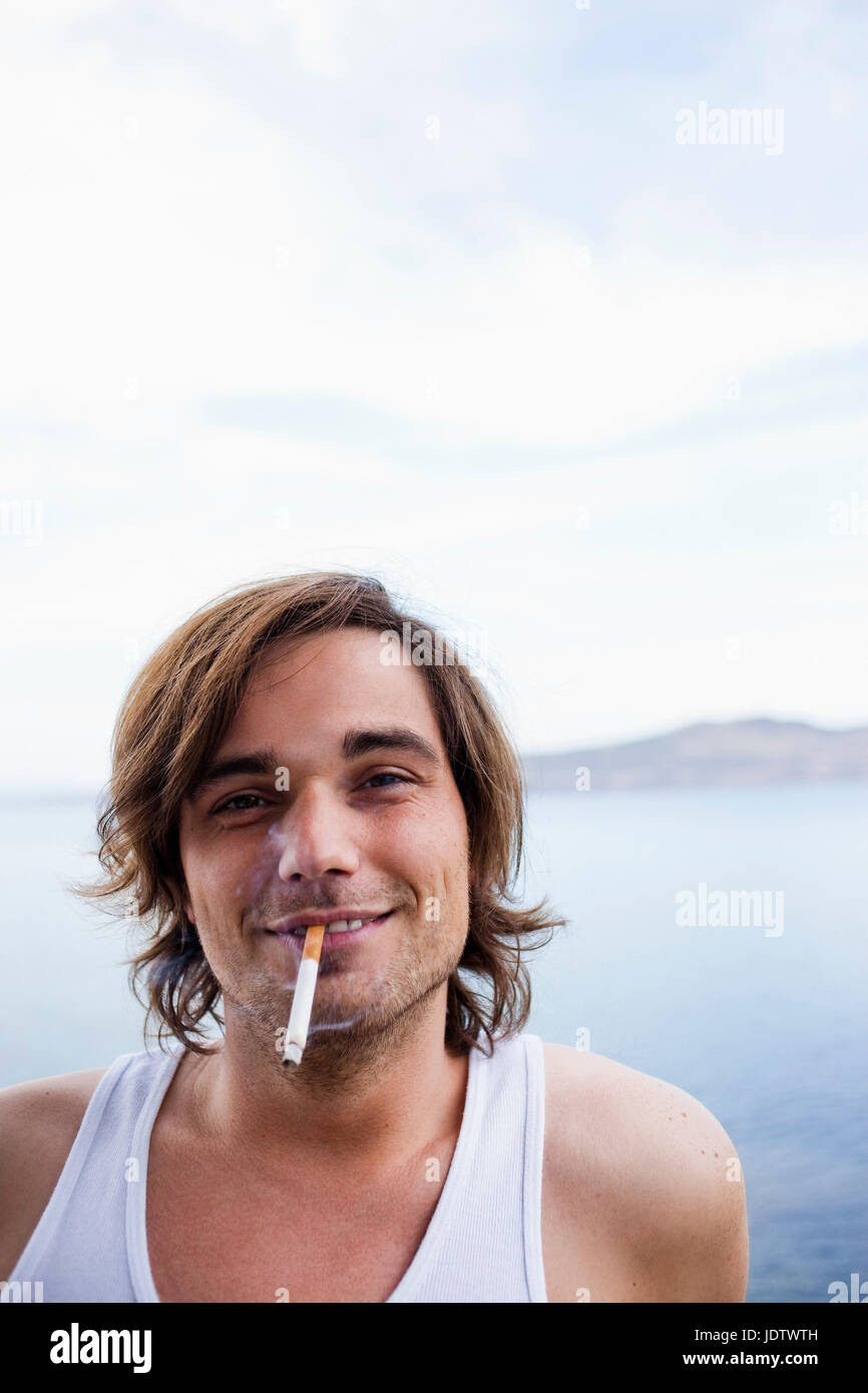 Young man smoking cigarette Stock Photo - Alamy