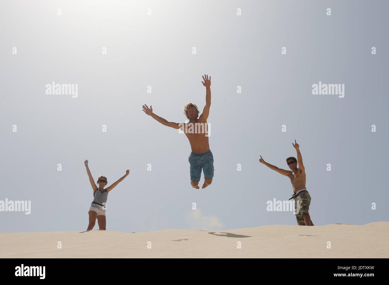 Man jumping over a big sand dune Stock Photo - Alamy