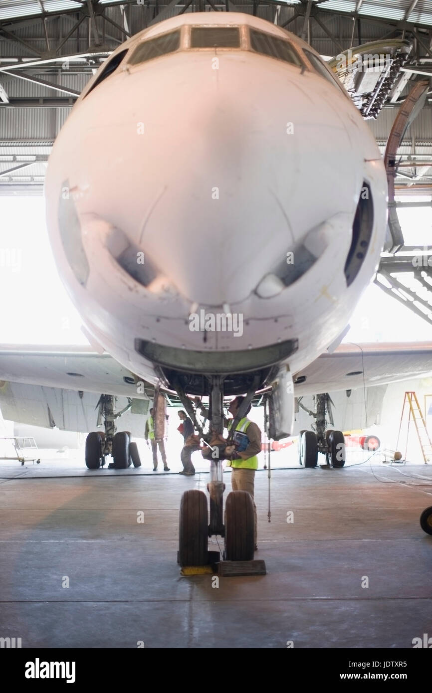 Aircraft worker checking airplane Stock Photo - Alamy