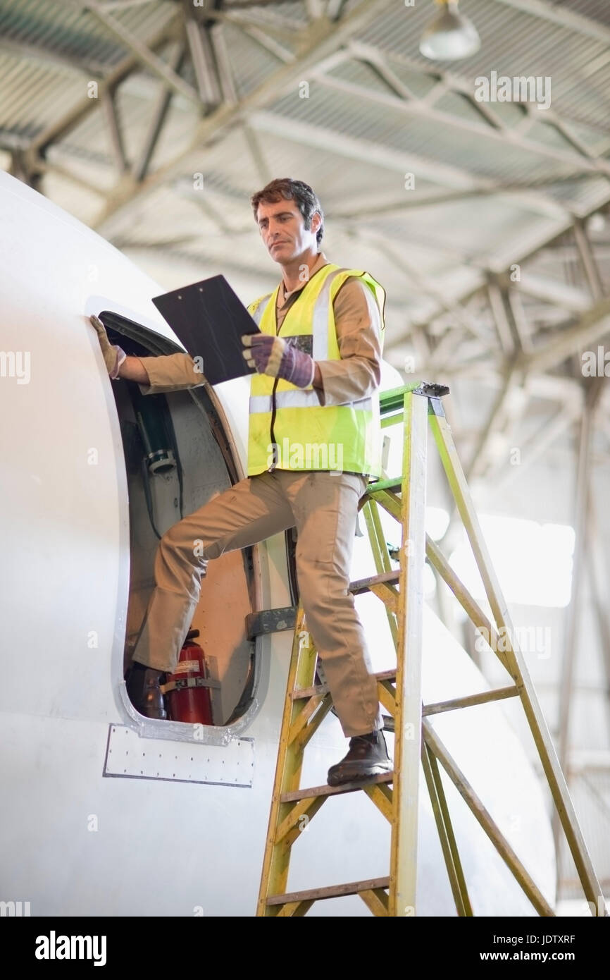 Aircraft worker checking airplane Stock Photo - Alamy