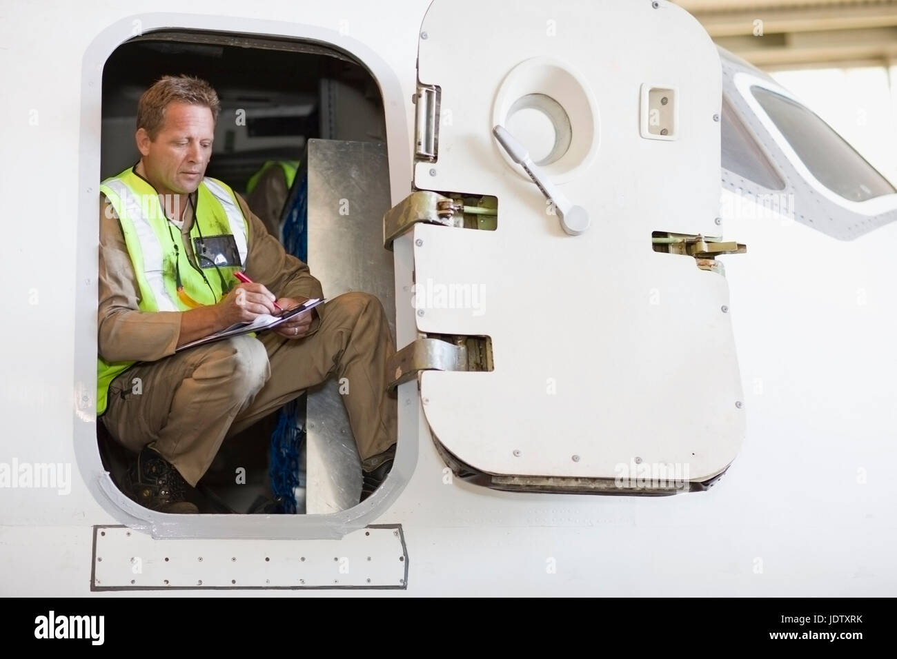 Aircraft worker checking airplane Stock Photo - Alamy