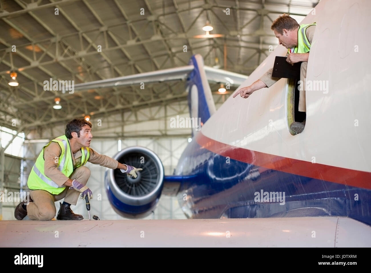 Aircraft workers checking airplane Stock Photo - Alamy