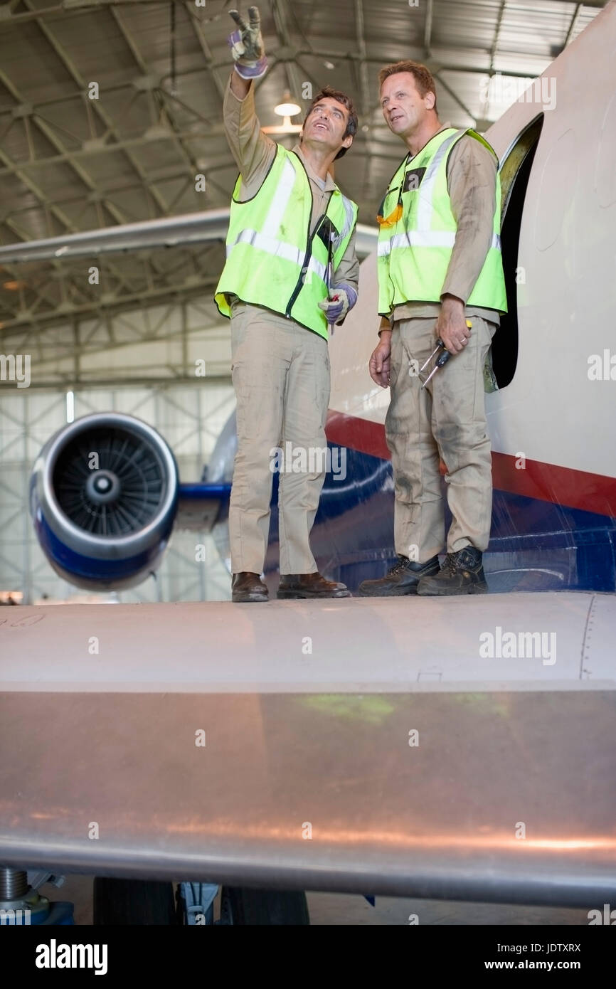 Aircraft workers talking on airplane Stock Photo - Alamy