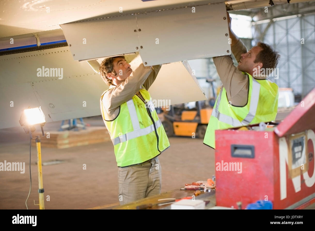 Aircraft workers checking airplane Stock Photo - Alamy