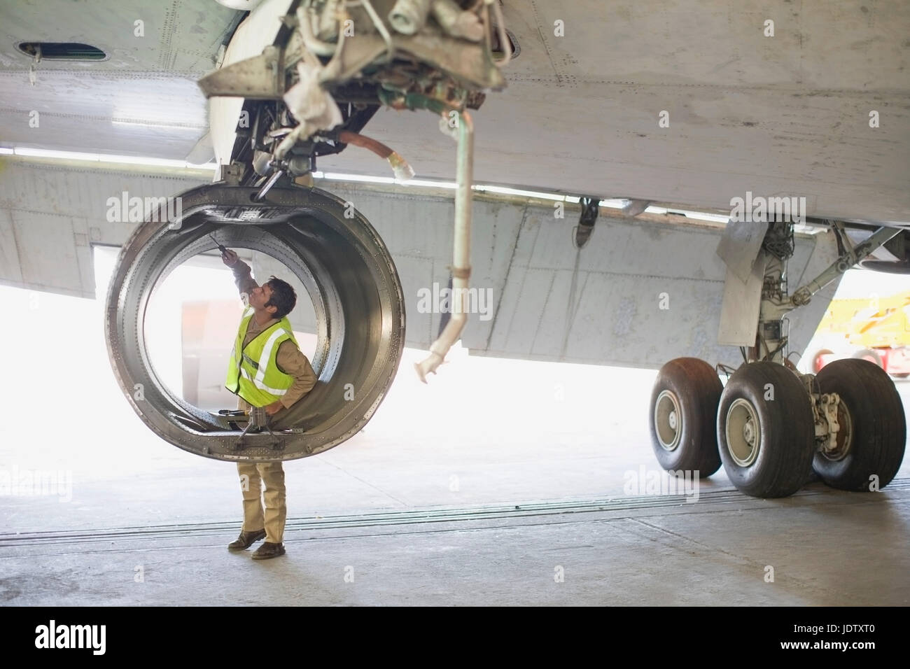 Aircraft worker checking airplane Stock Photo - Alamy