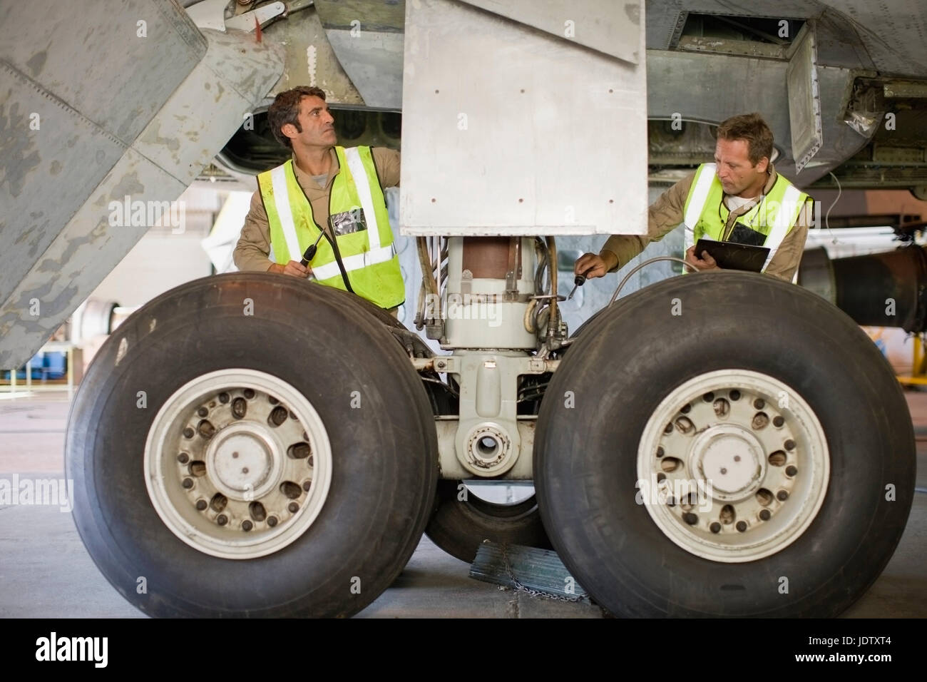 Aircraft workers checking airplane Stock Photo - Alamy