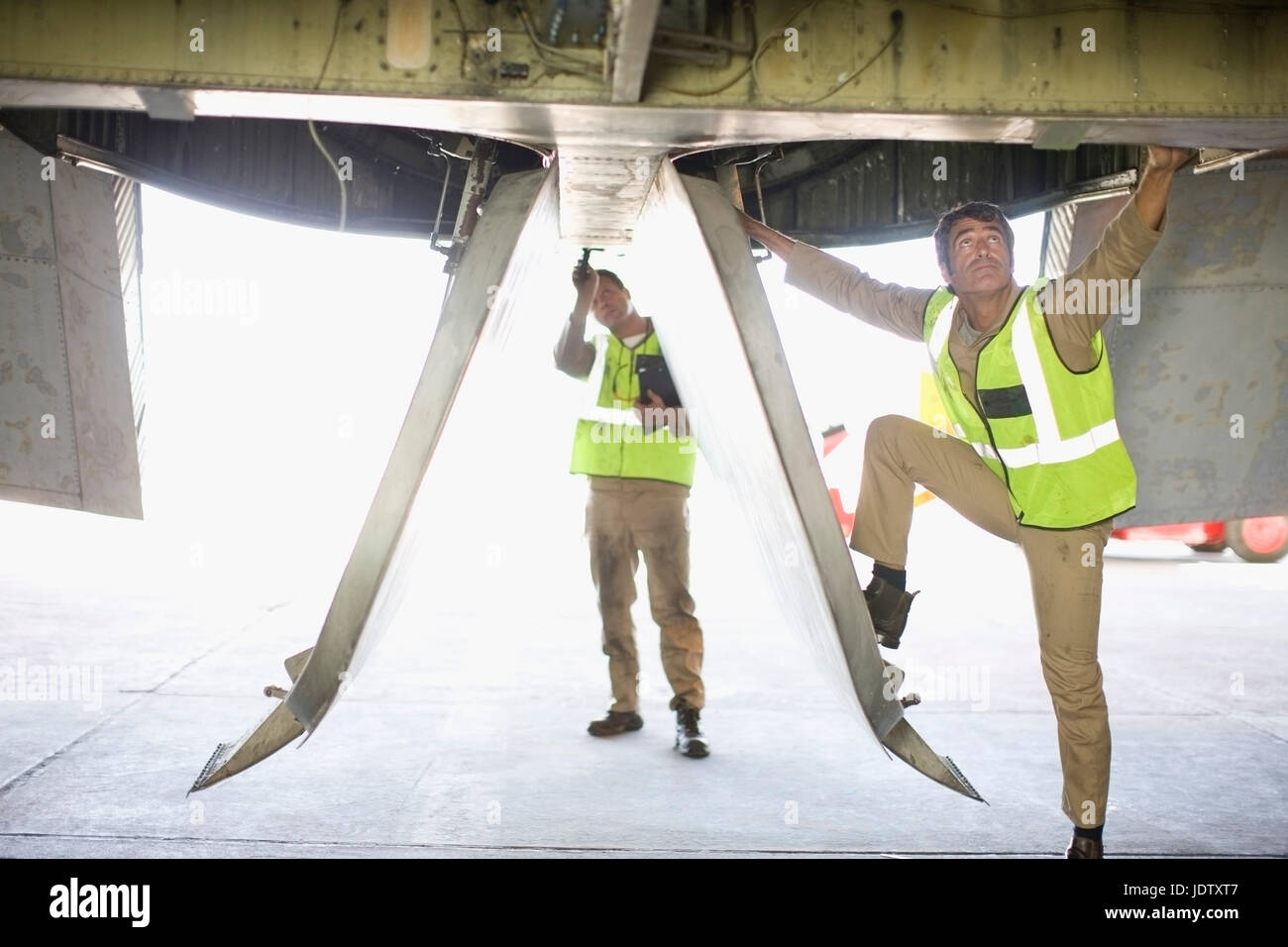 Aircraft workers checking airplane Stock Photo - Alamy