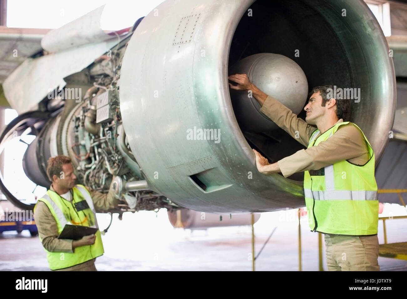 Aircraft workers checking airplane Stock Photo - Alamy