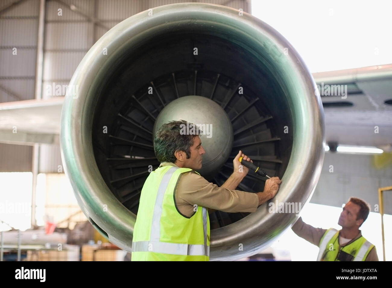 Aircraft workers checking airplane Stock Photo - Alamy