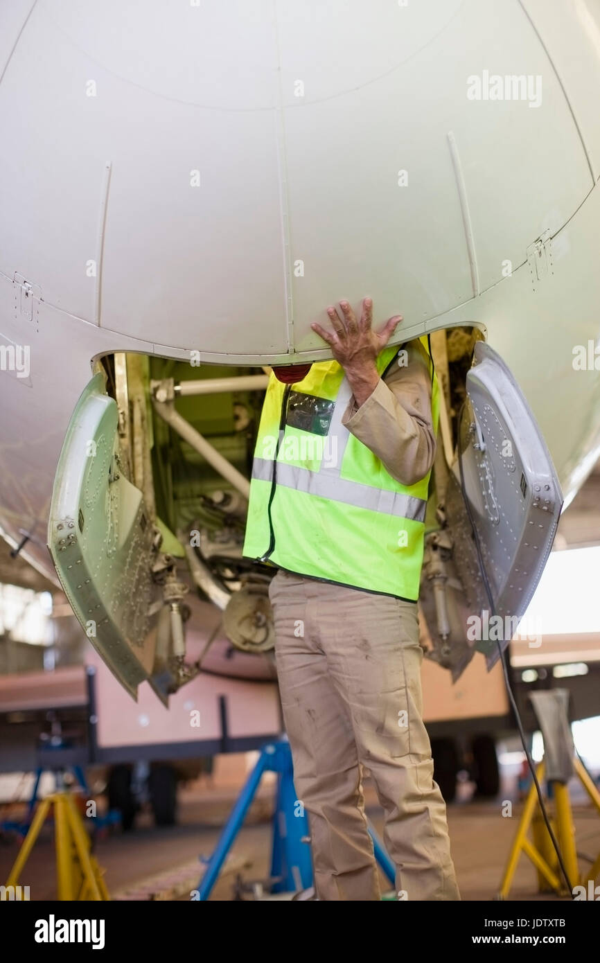 Aircraft worker checking airplane Stock Photo - Alamy