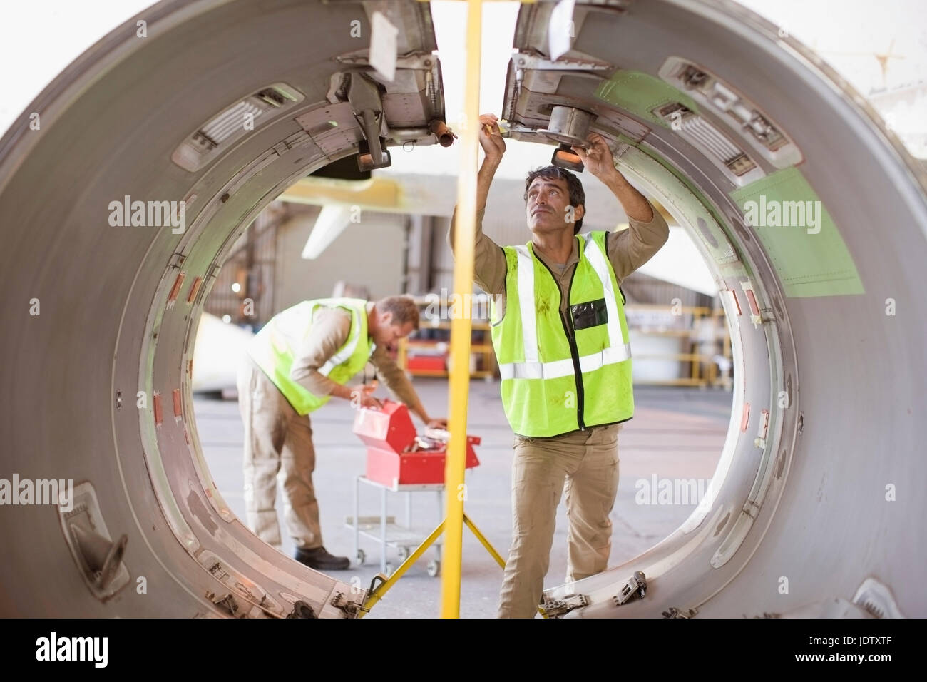 Aircraft workers checking airplane part Stock Photo - Alamy
