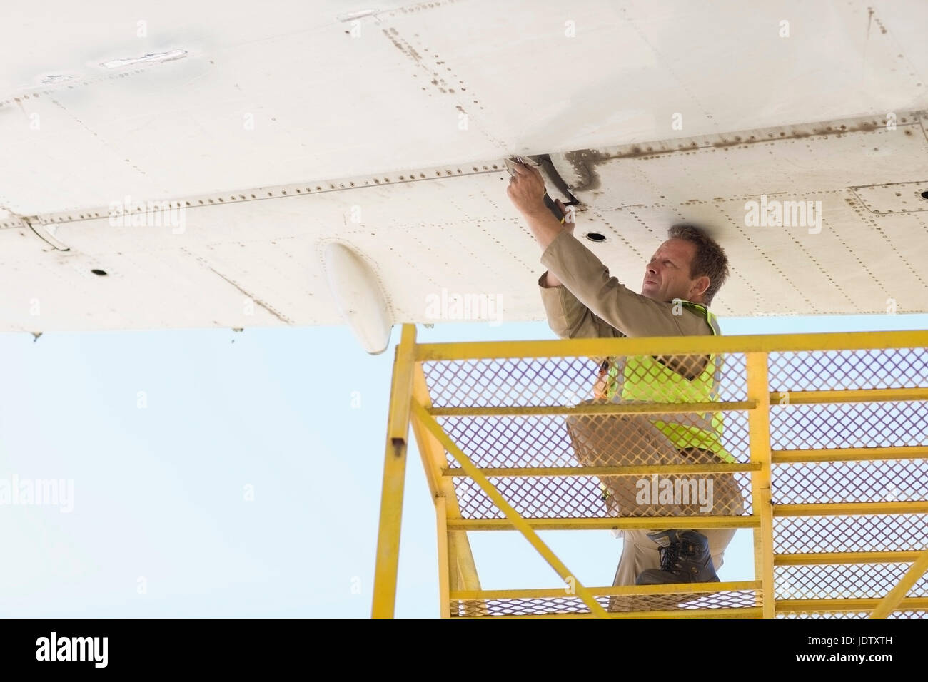Aircraft worker repairing airplane Stock Photo - Alamy
