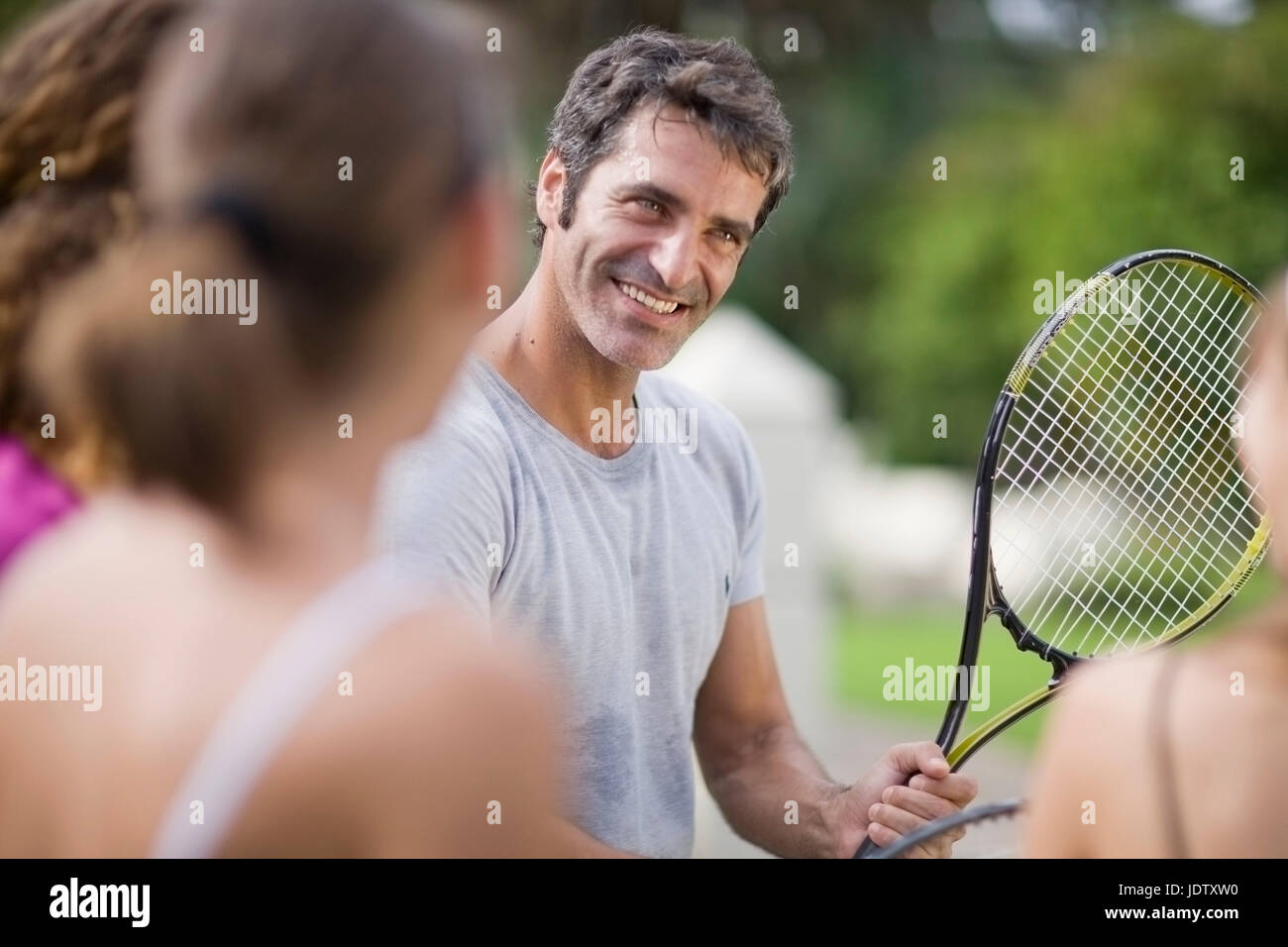 Tennis coach demonstrating for students Stock Photo - Alamy