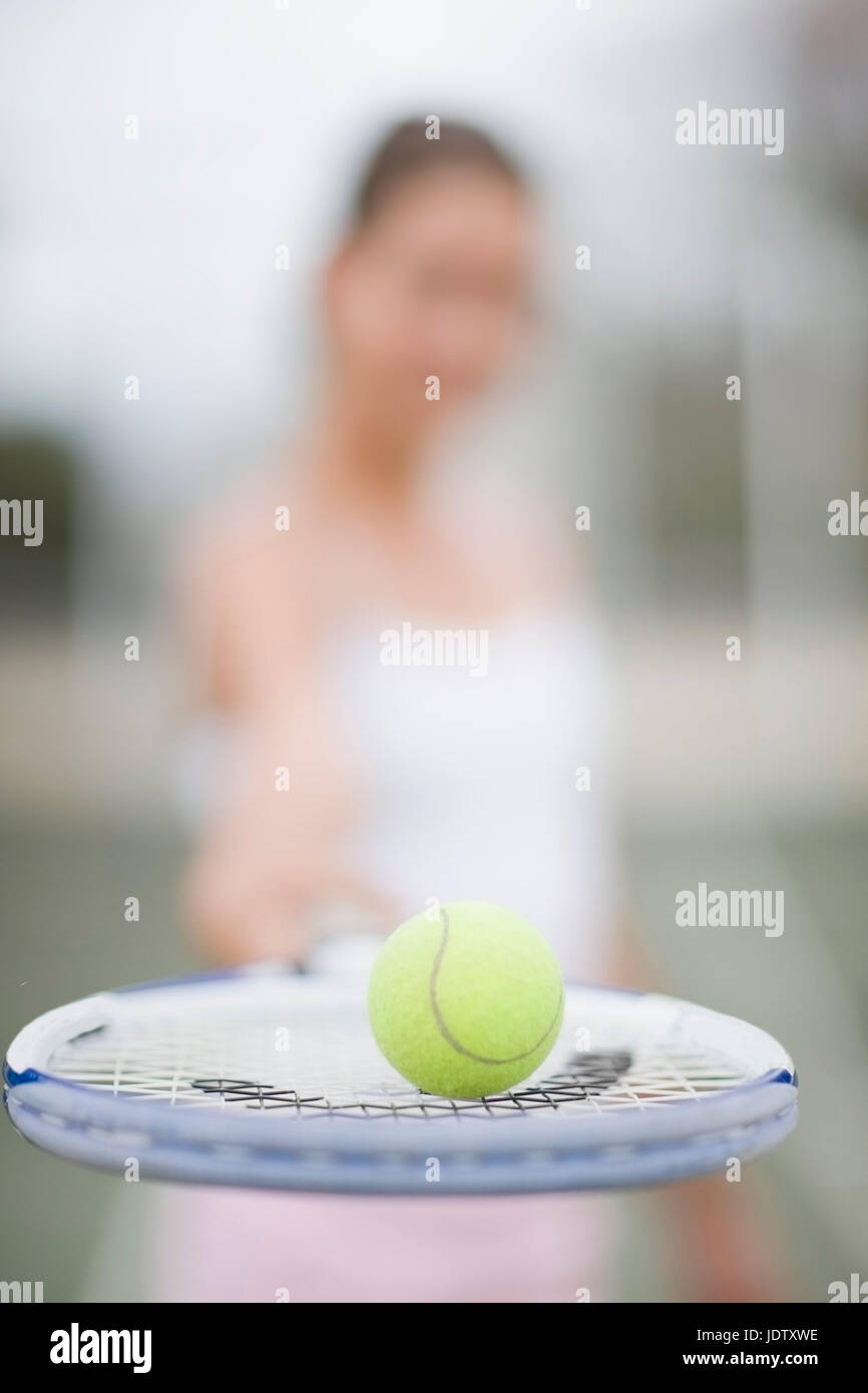 Tennis ball balanced on racket Stock Photo - Alamy