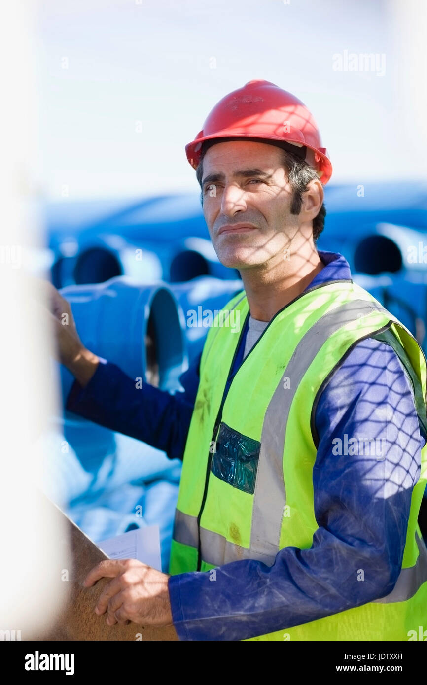 Worker examining tubes in factory Stock Photo - Alamy