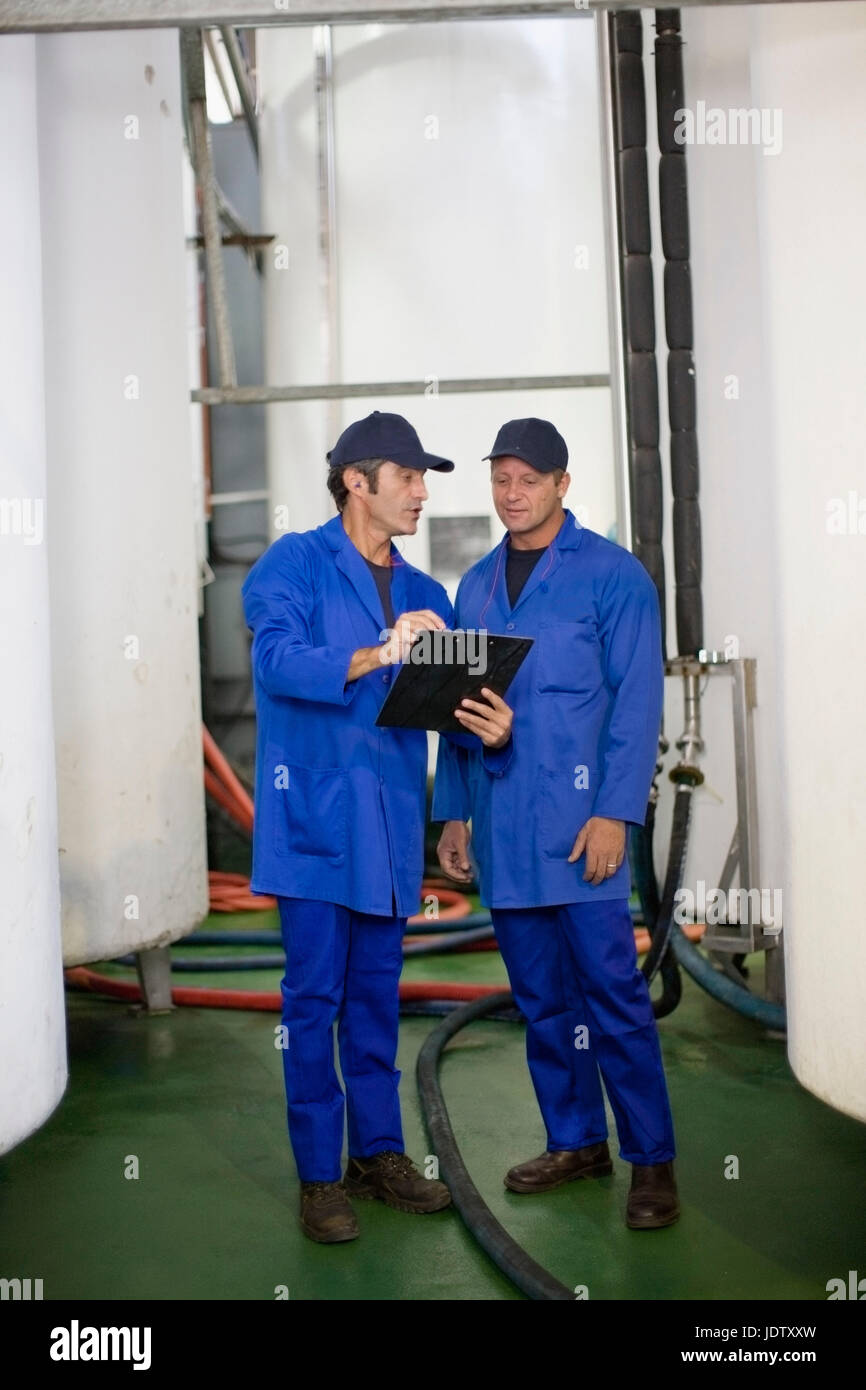 Workers reading clipboard in factory Stock Photo - Alamy
