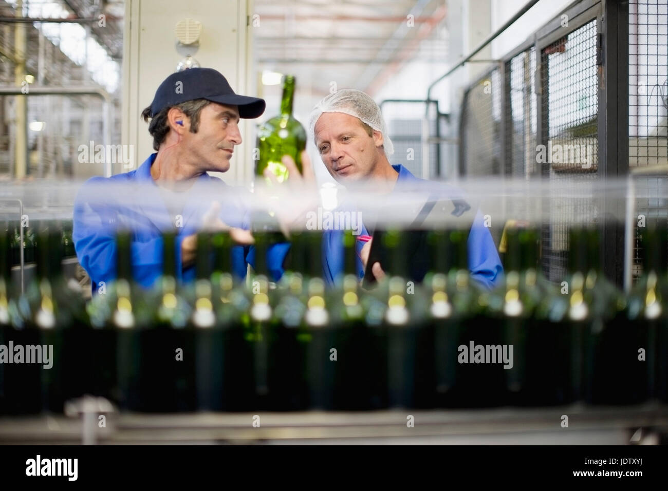 Workers checking bottles in factory Stock Photo - Alamy