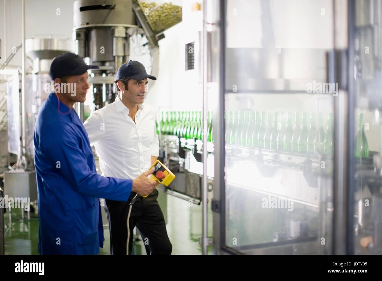 Workers operating machinery in factory Stock Photo - Alamy