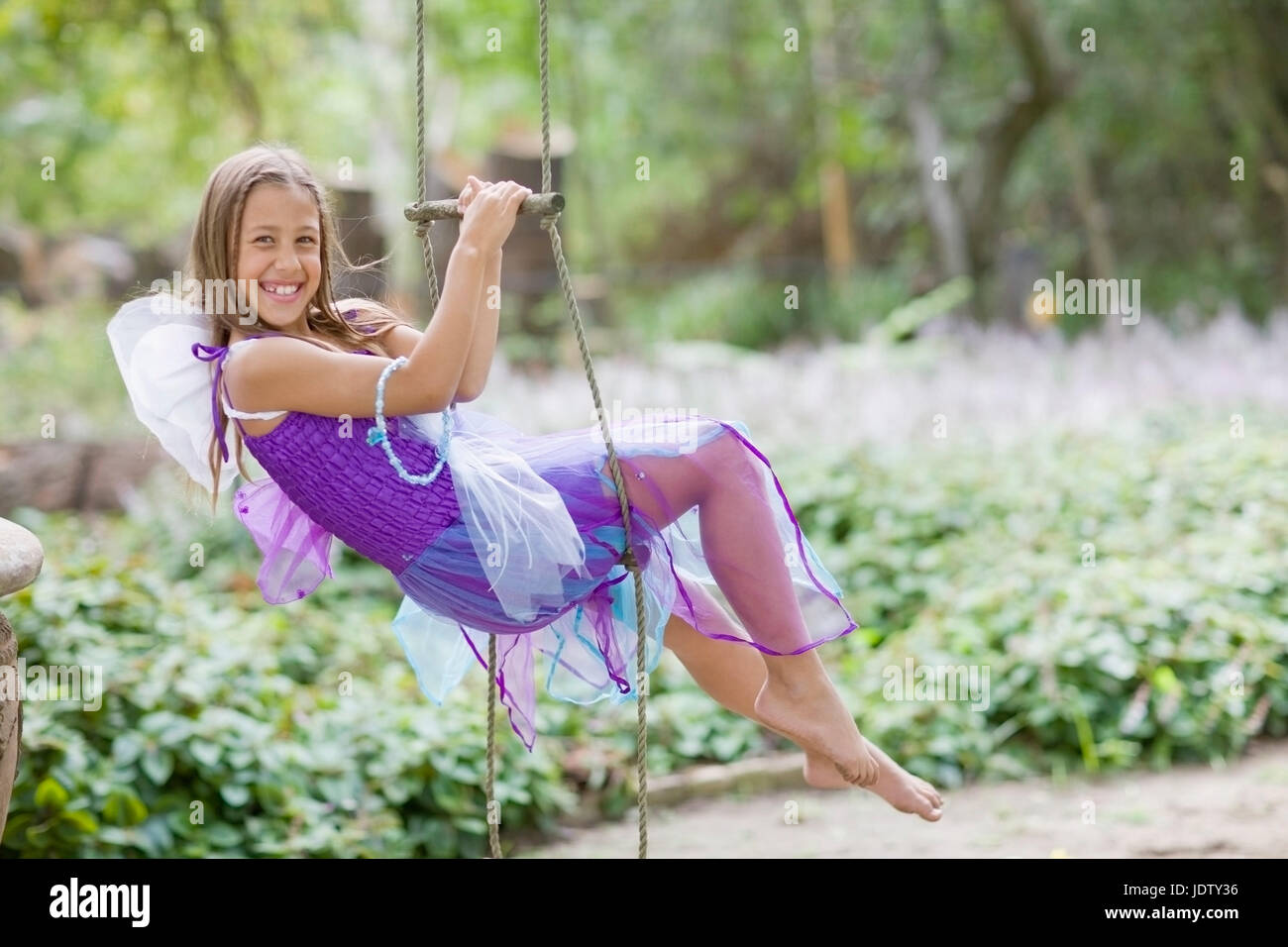 Girl climbing rope ladder in costume Stock Photo - Alamy
