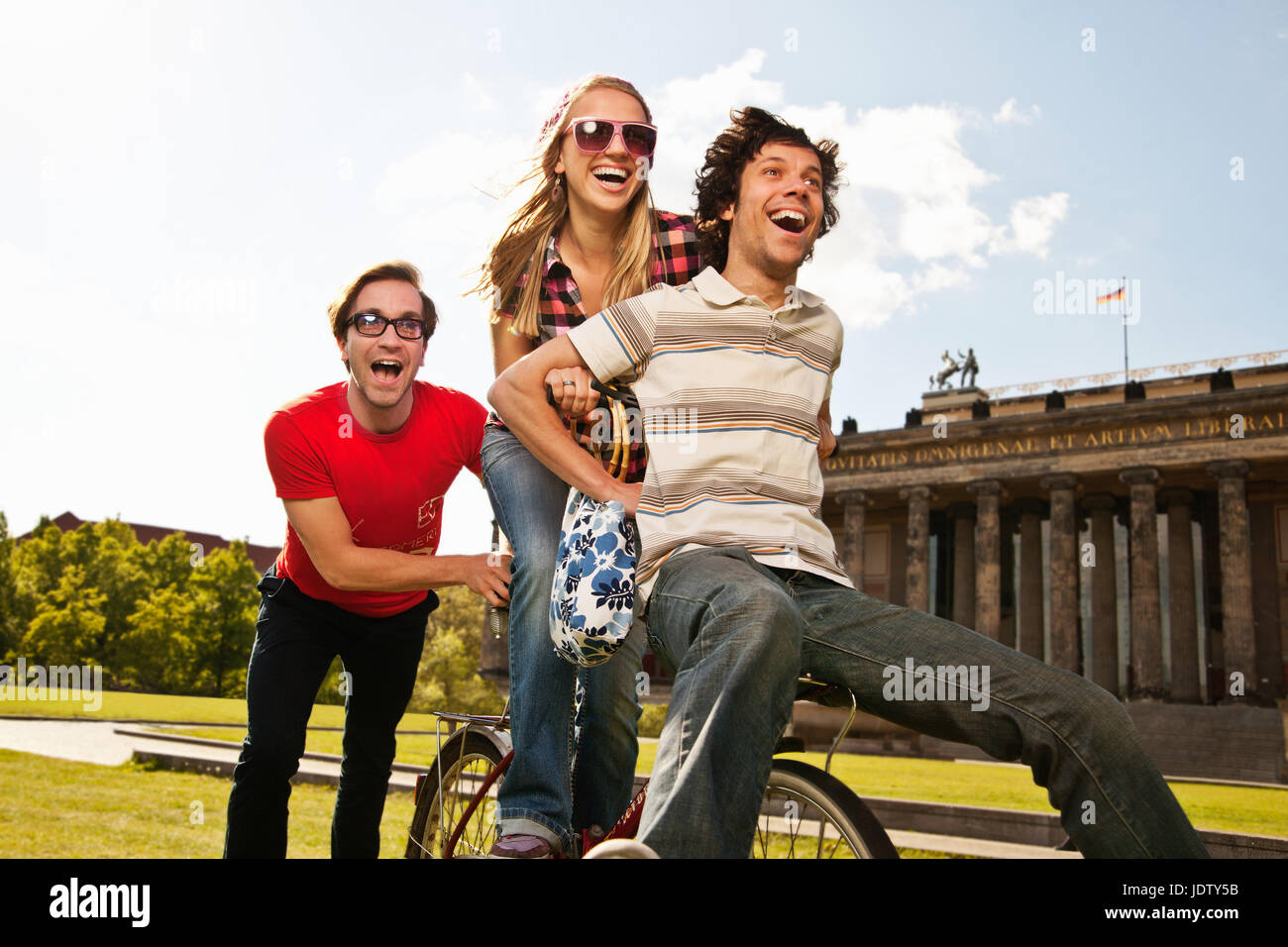 Friends riding bike together in park Stock Photo - Alamy
