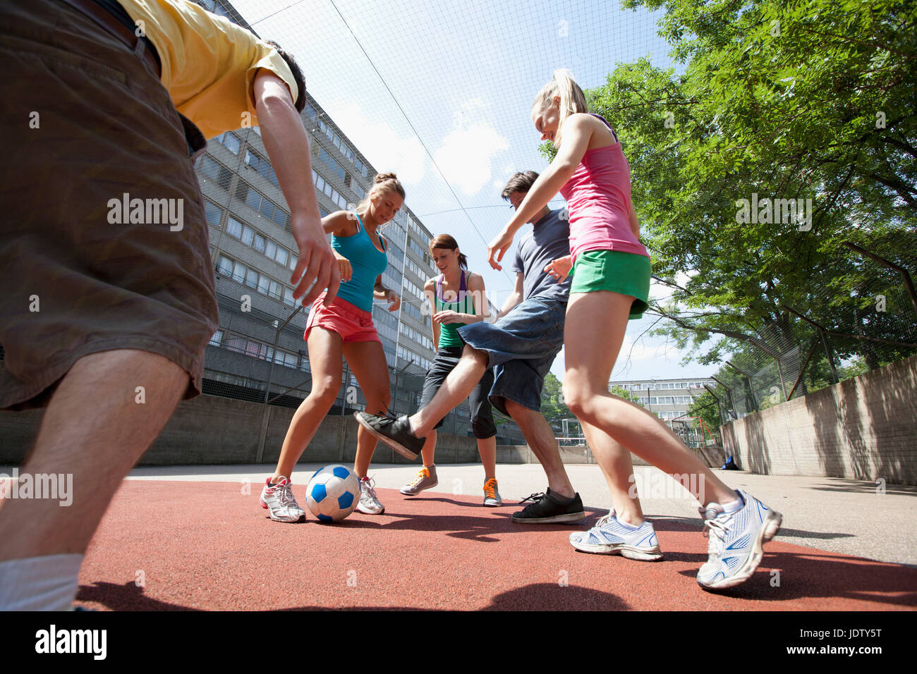 Friends playing soccer on city street Stock Photo - Alamy