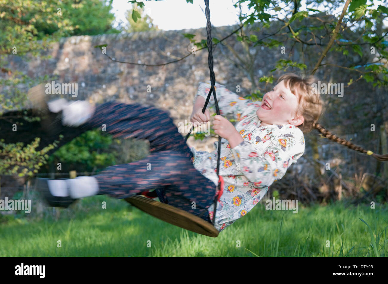 Girl spinning on tree swing Stock Photo - Alamy