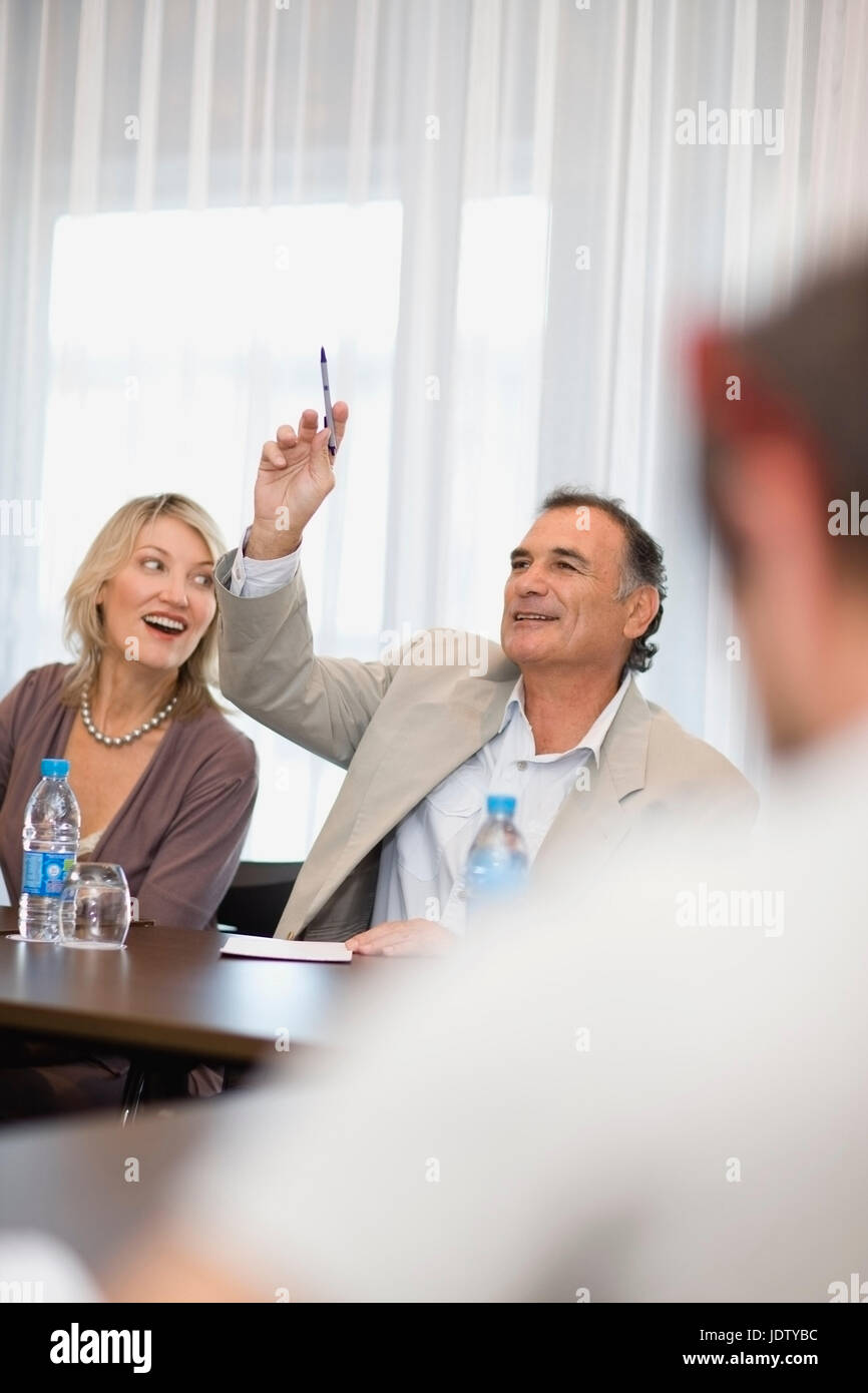 Businessman raising hand in meeting Stock Photo - Alamy