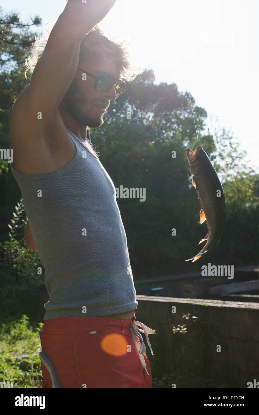 Man catching fish in river Stock Photo - Alamy