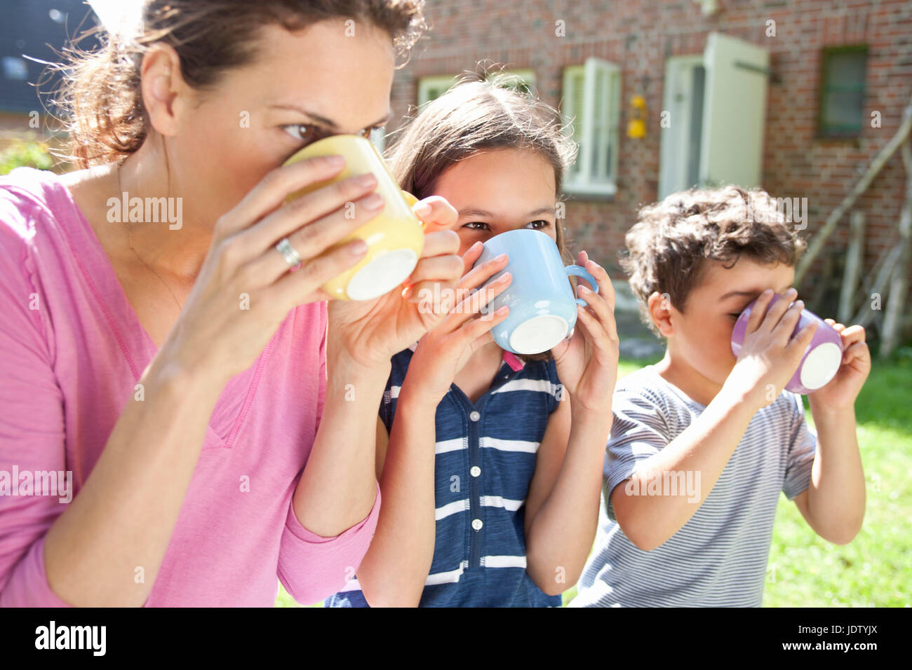 Mother and children drinking outdoors Stock Photo - Alamy