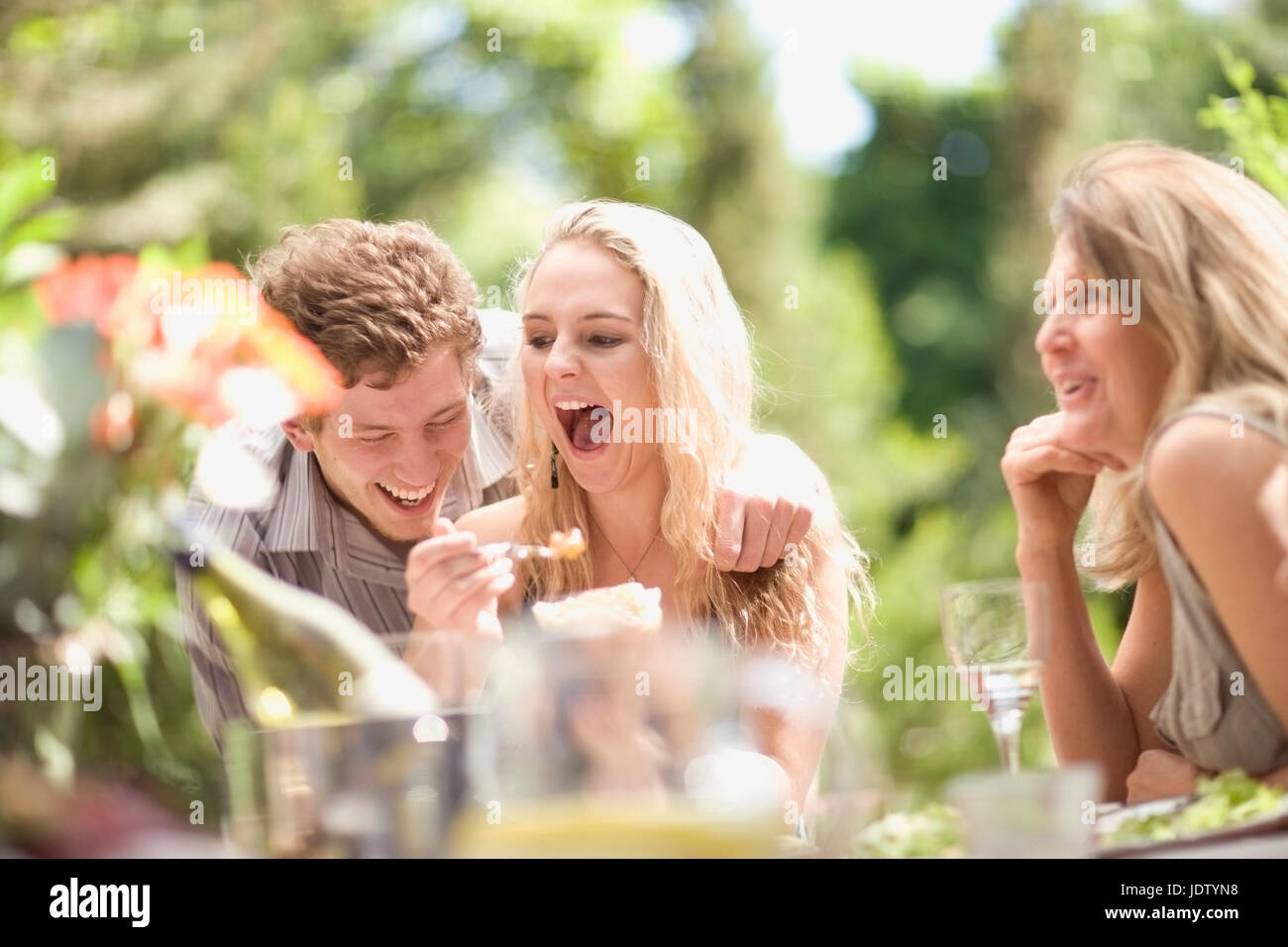 Family laughing at table outdoors Stock Photo - Alamy