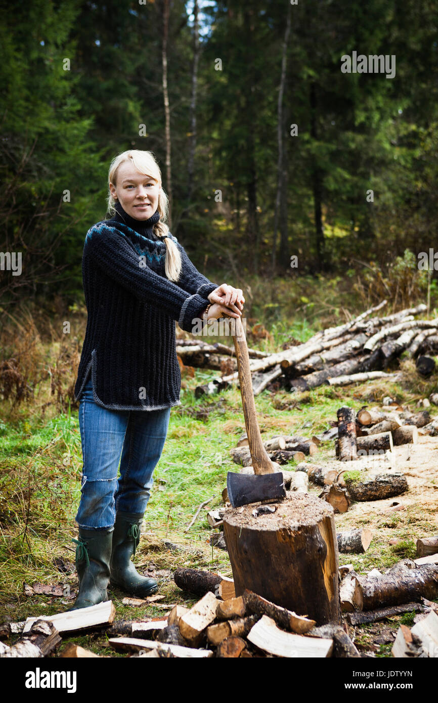 Woman chopping firewood in forest Stock Photo - Alamy