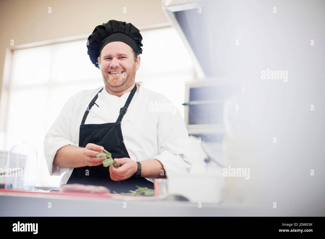 Smiling chef at work in kitchen Stock Photo - Alamy