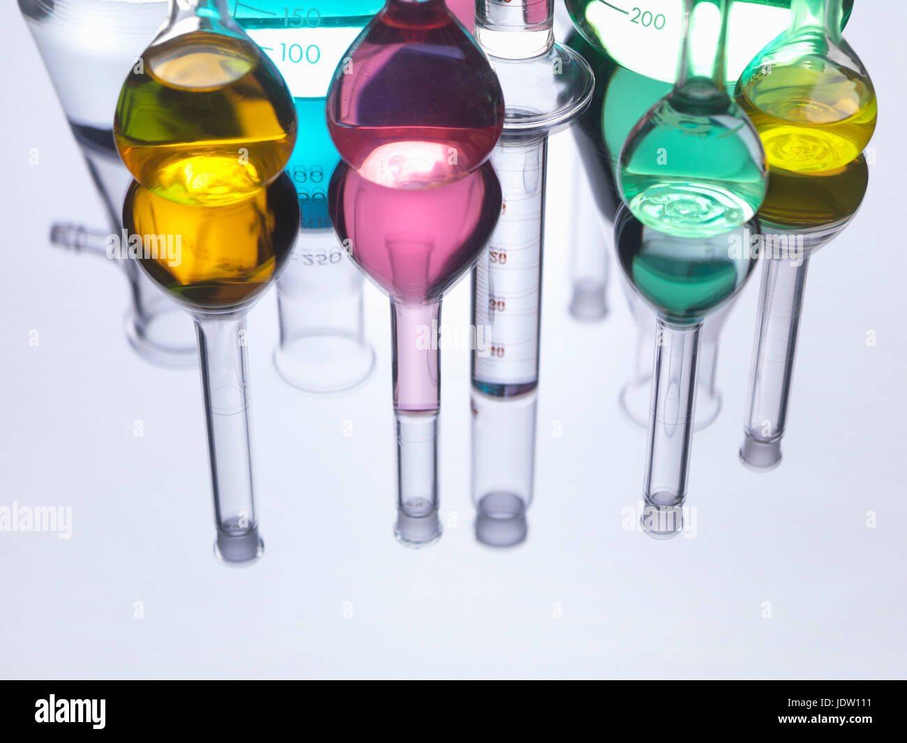 Beakers with liquids on reflective table Stock Photo - Alamy