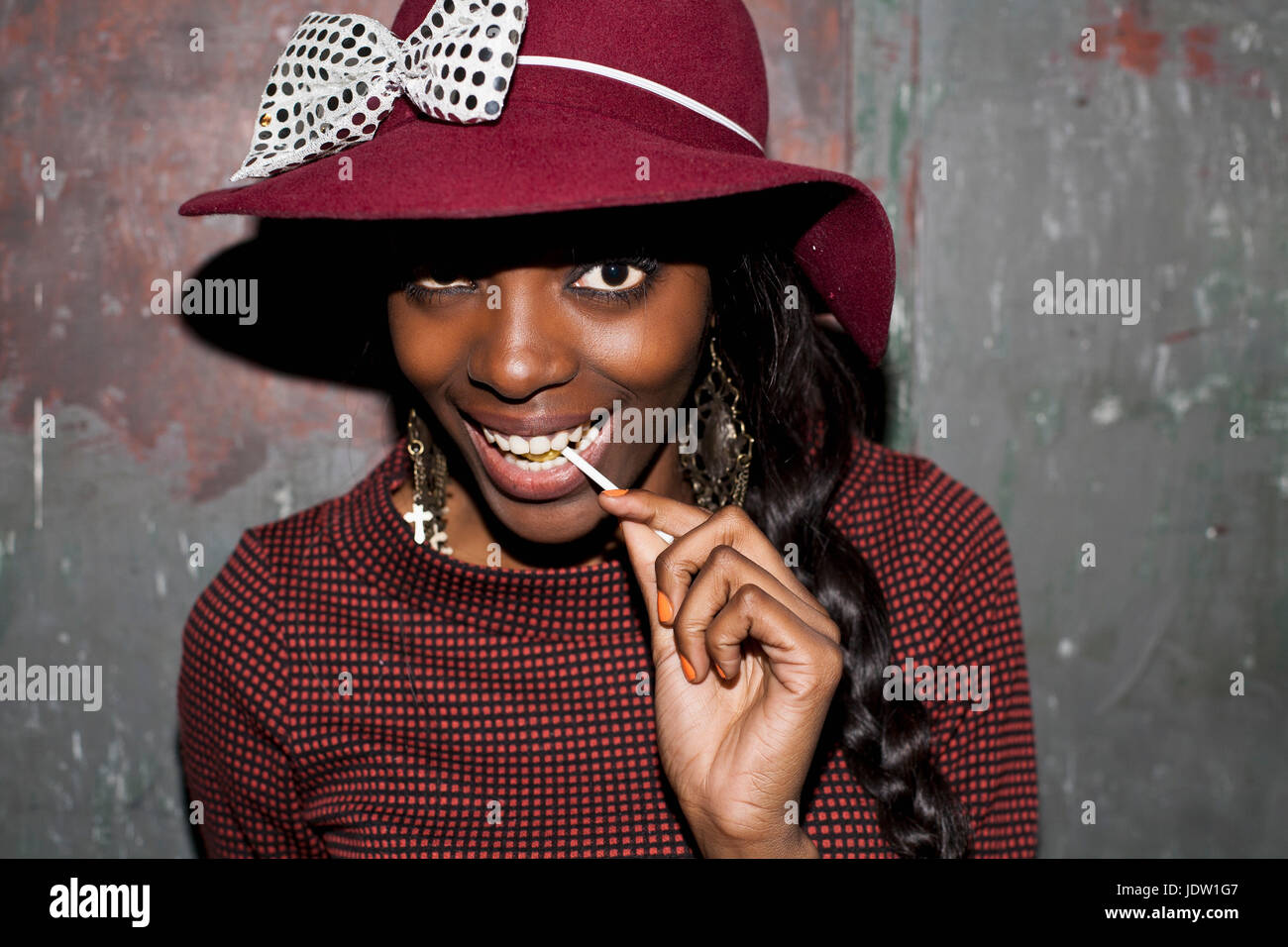 Smiling woman chewing on stick Stock Photo - Alamy