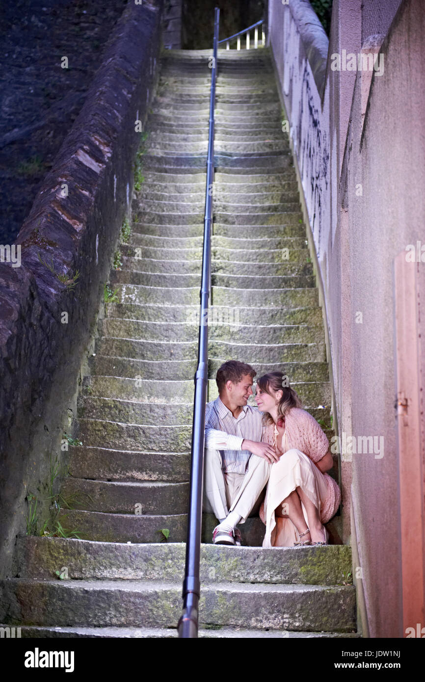 Couple sitting on urban steps Stock Photo - Alamy
