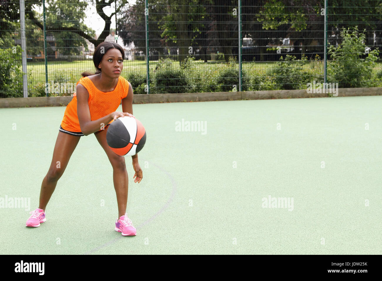 Woman playing basketball on court Stock Photo - Alamy
