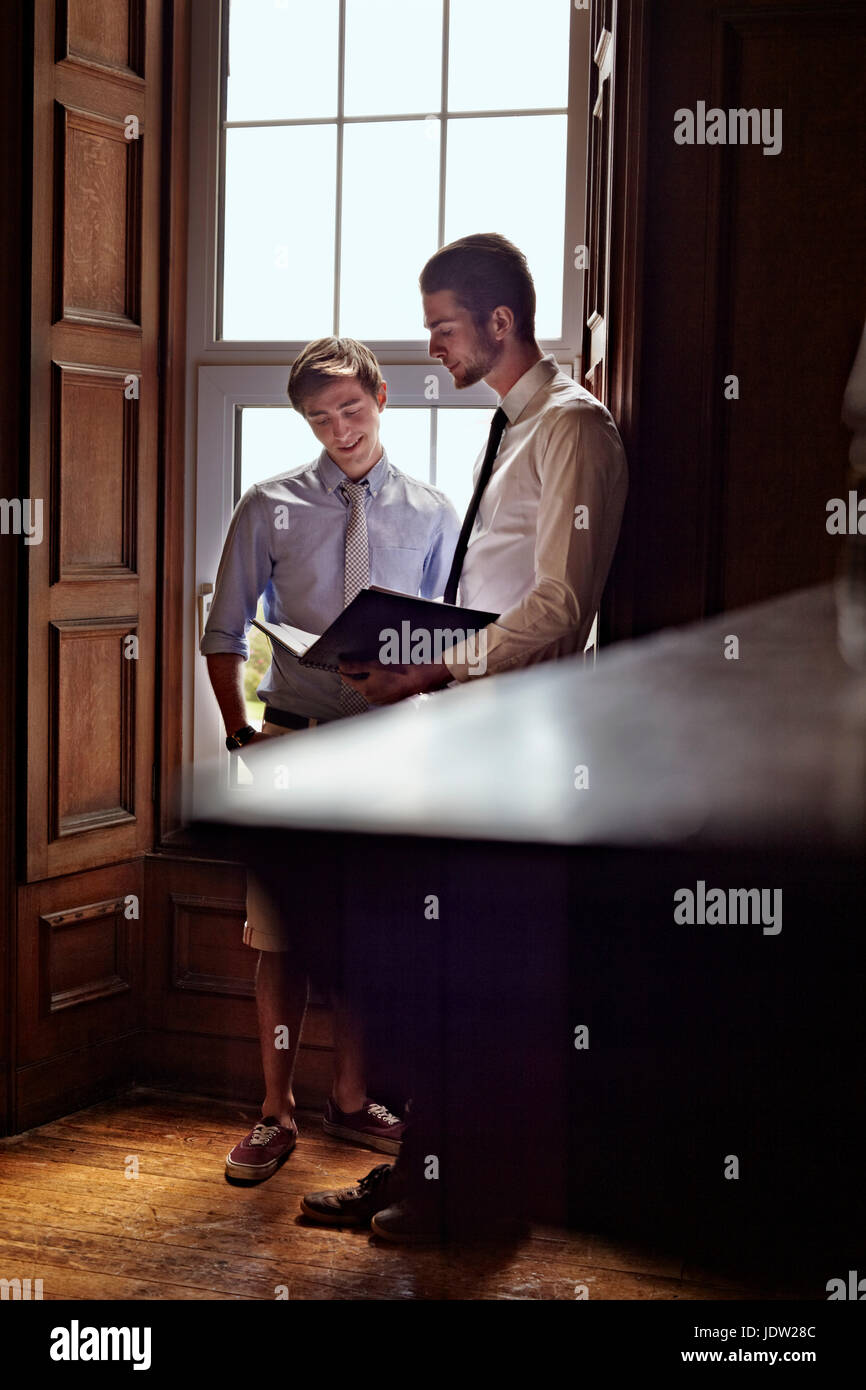 Businessmen talking by window Stock Photo - Alamy