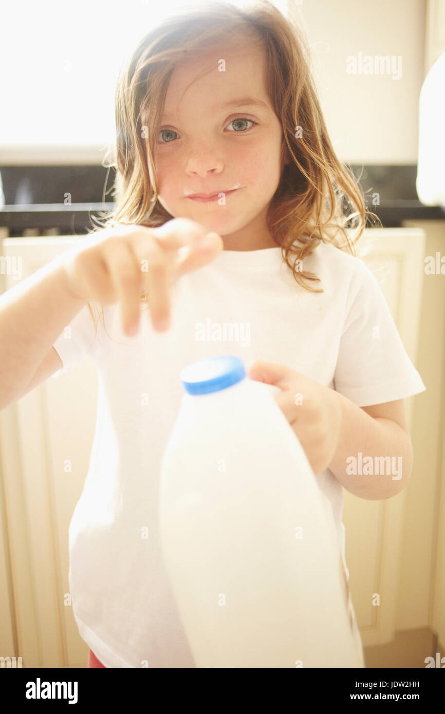 Girl opening jug of milk Stock Photo - Alamy