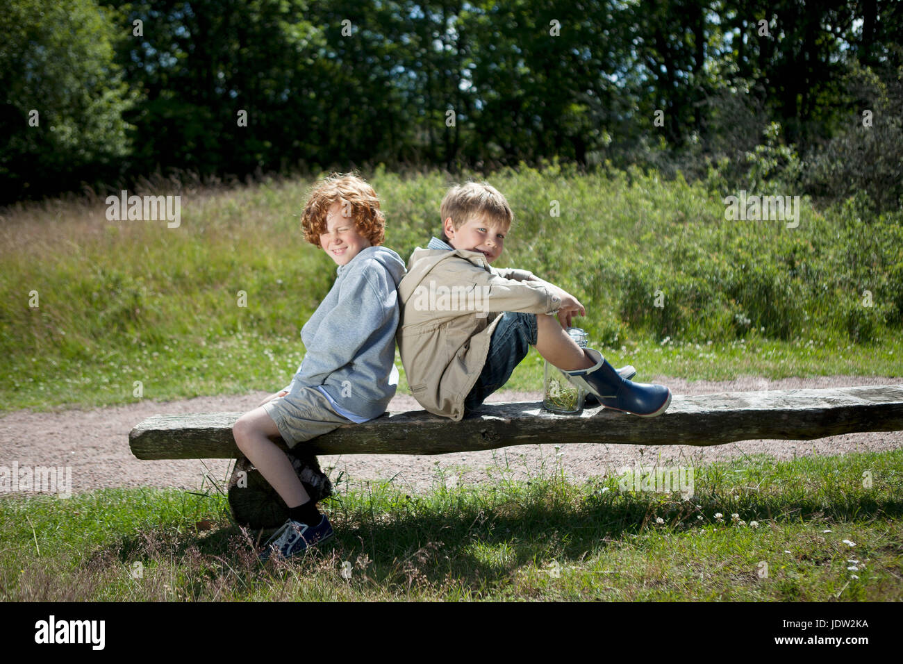 Children sitting on wooden bench Stock Photo - Alamy