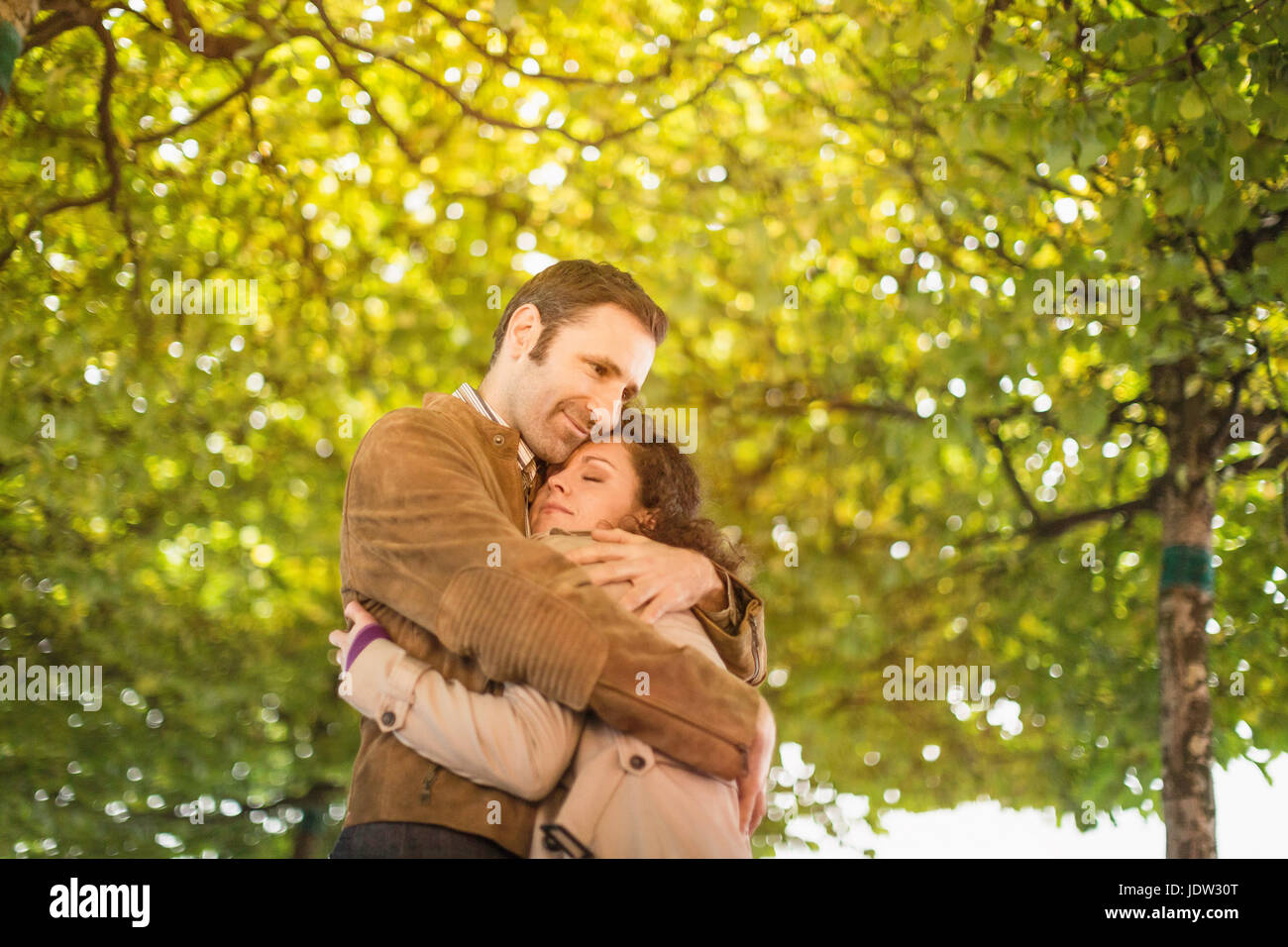 Couple hugging in park Stock Photo - Alamy