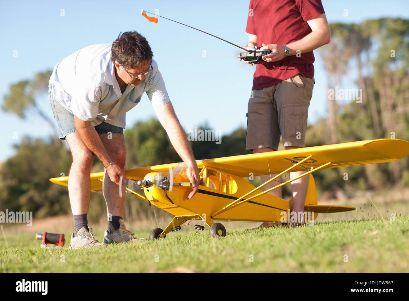Men playing with toy airplane in park Stock Photo - Alamy