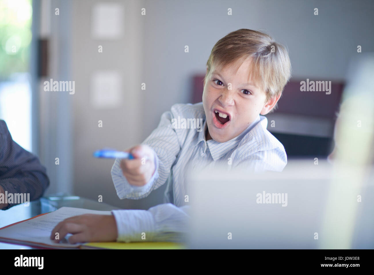 Boy playing businessman at desk Stock Photo - Alamy
