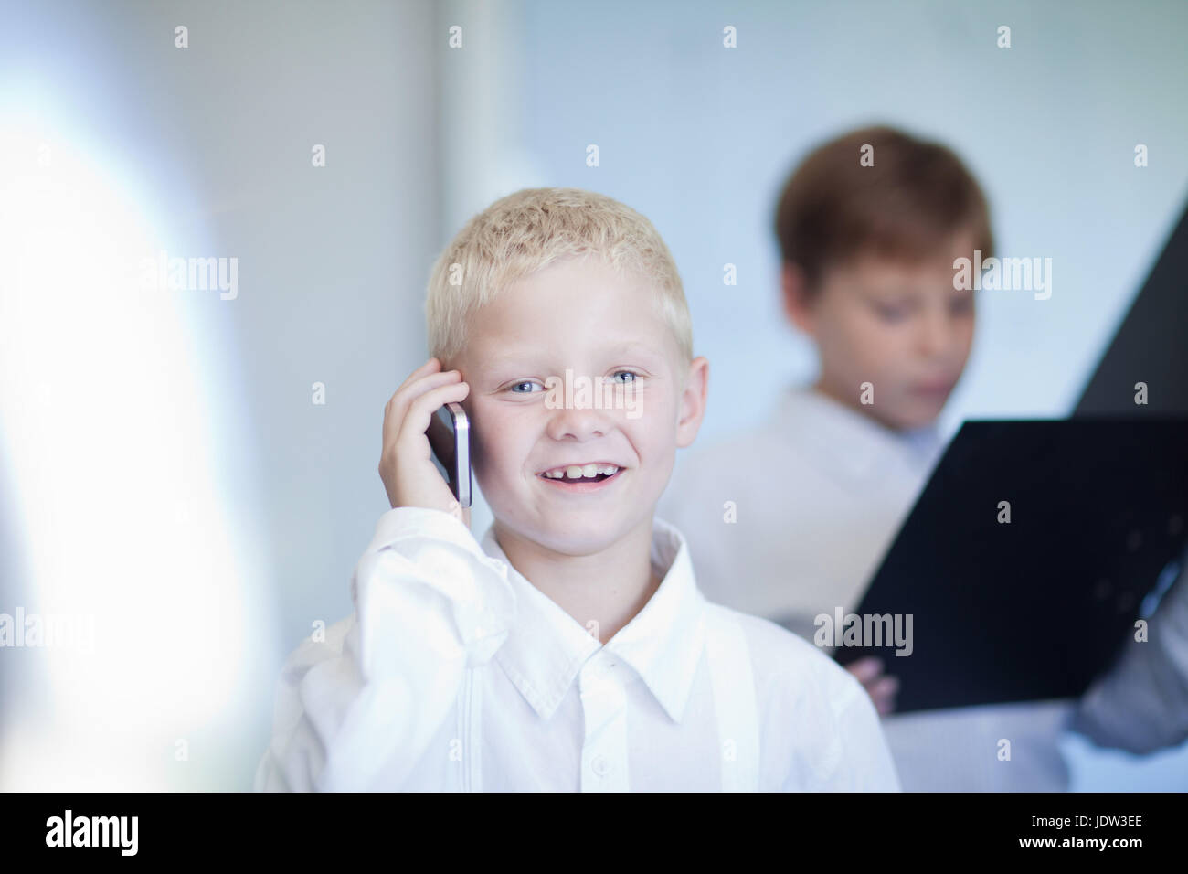 Boy playing businessman at desk Stock Photo - Alamy