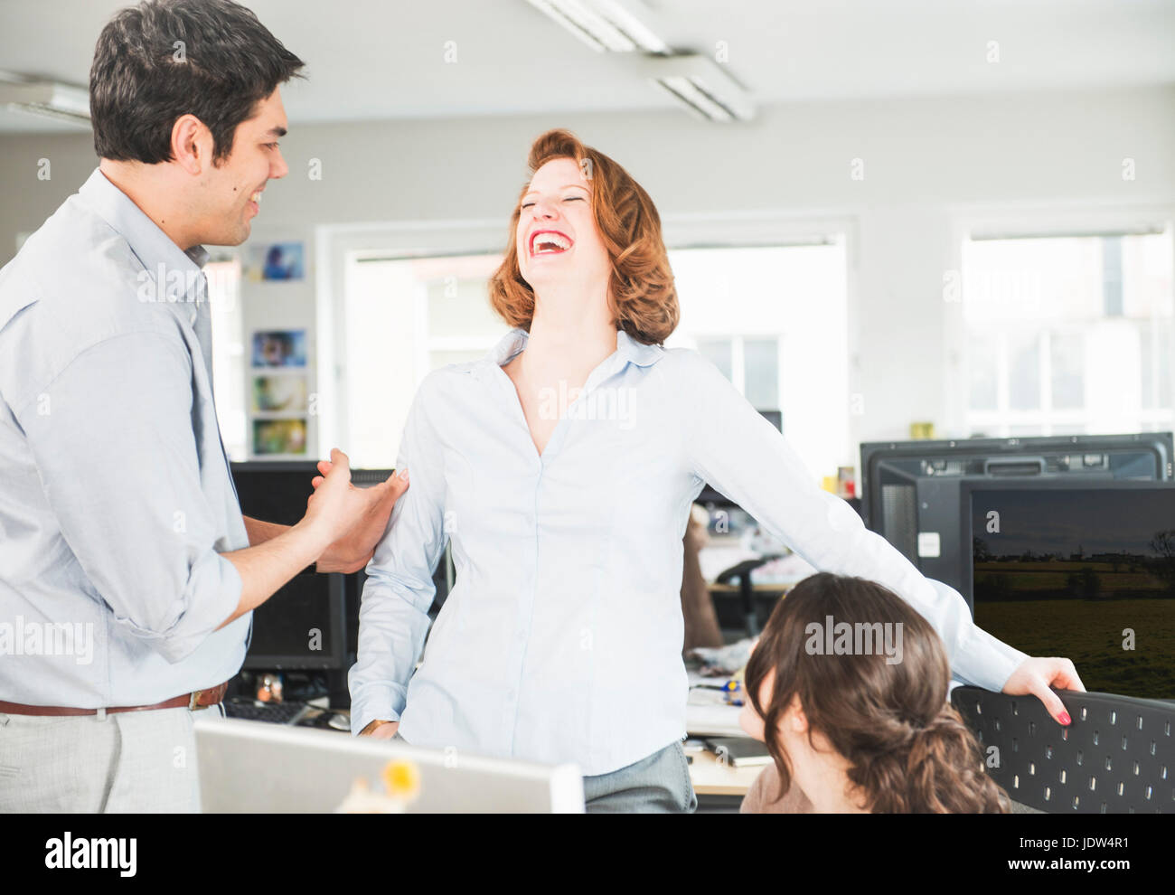 Colleagues laughing in office Stock Photo - Alamy