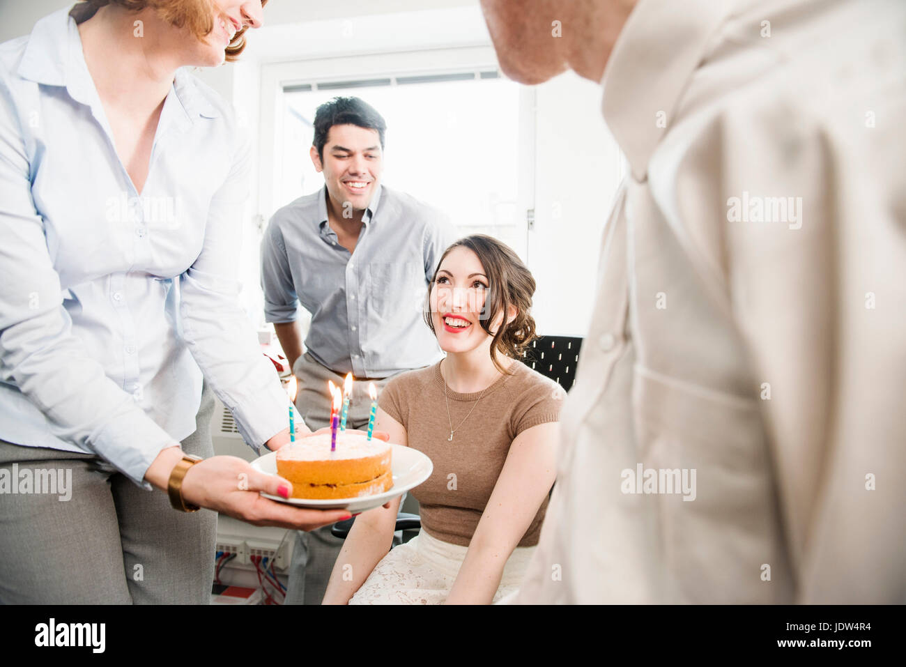 Female office worker receiving birthday cake Stock Photo - Alamy