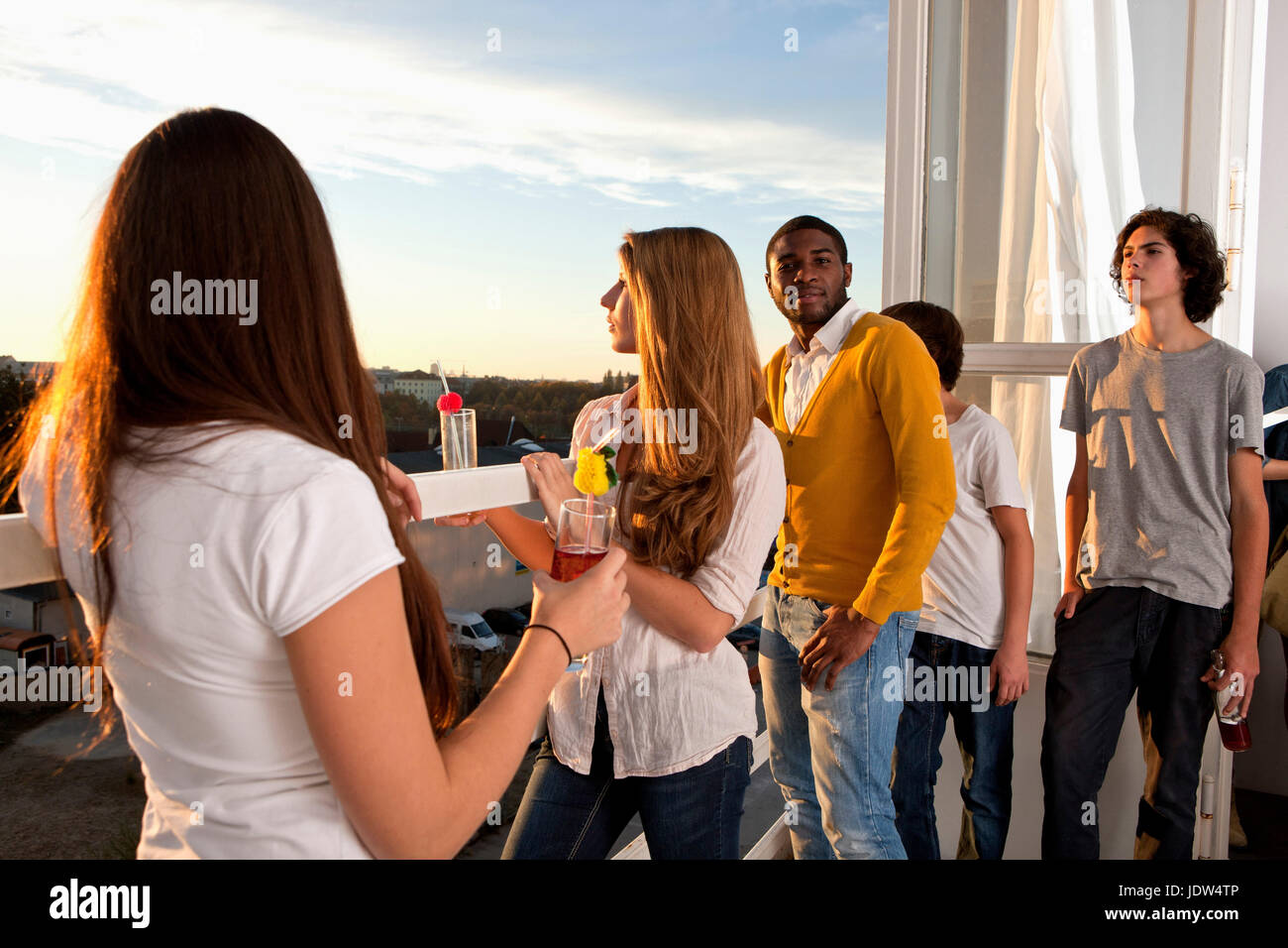 Group of friends at house party on balcony Stock Photo - Alamy
