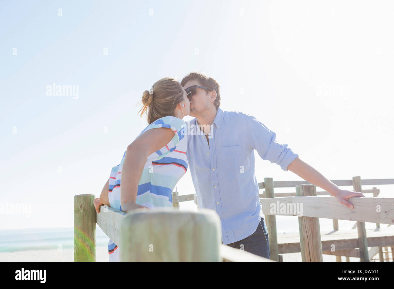 Couple kissing by wooden fence Stock Photo - Alamy