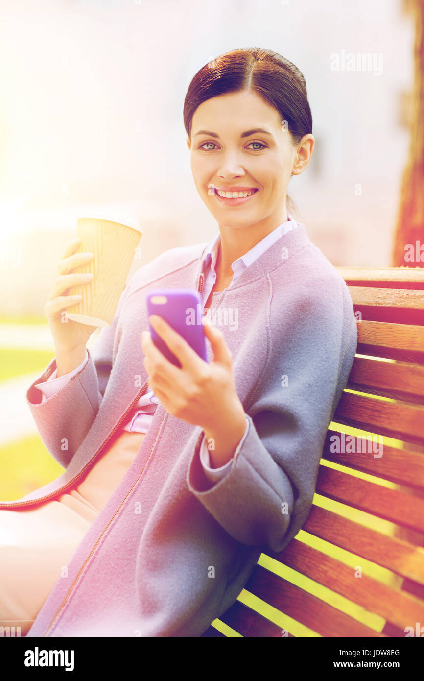 smiling woman with coffee and smartphone Stock Photo - Alamy