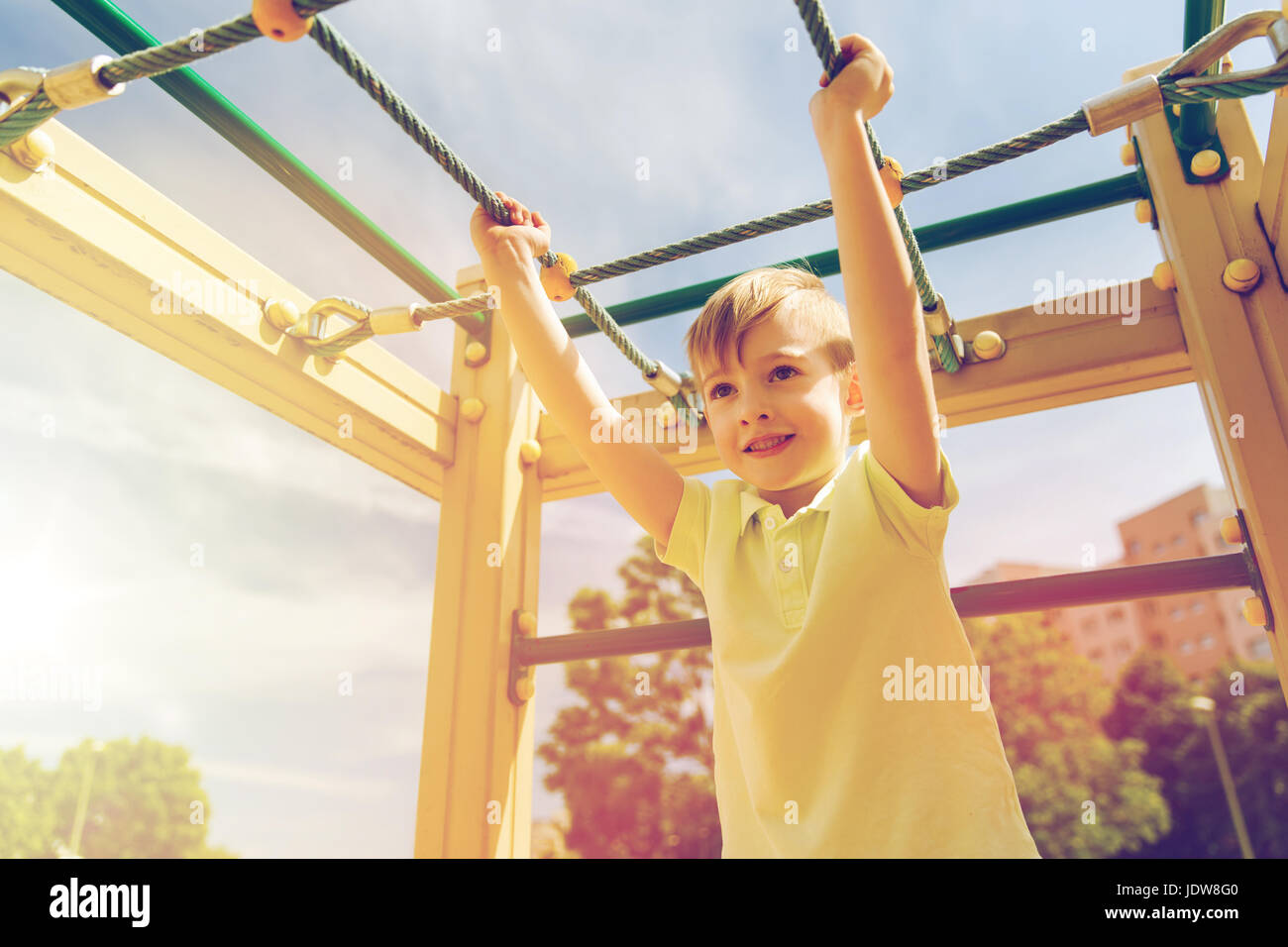 happy little boy climbing on children playground Stock Photo - Alamy