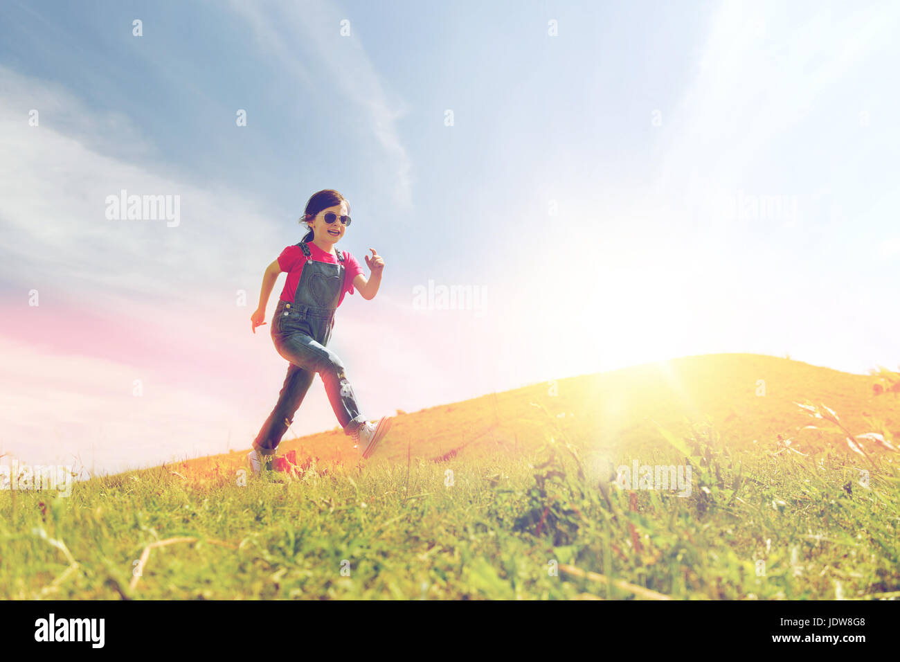 happy little girl running on green summer field Stock Photo - Alamy